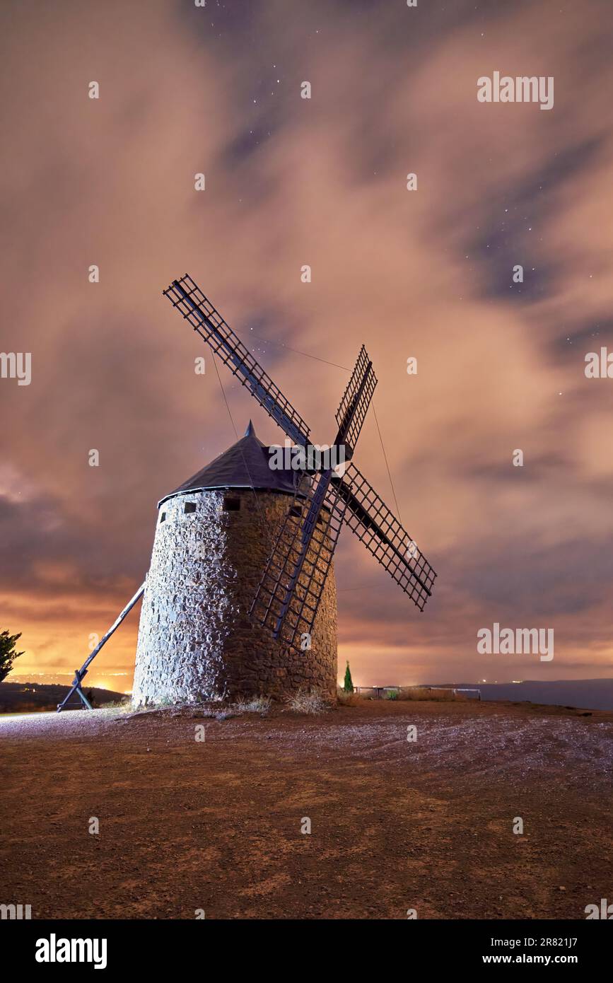 An old windmill in the night with clouds. Clouds on the run, night ...