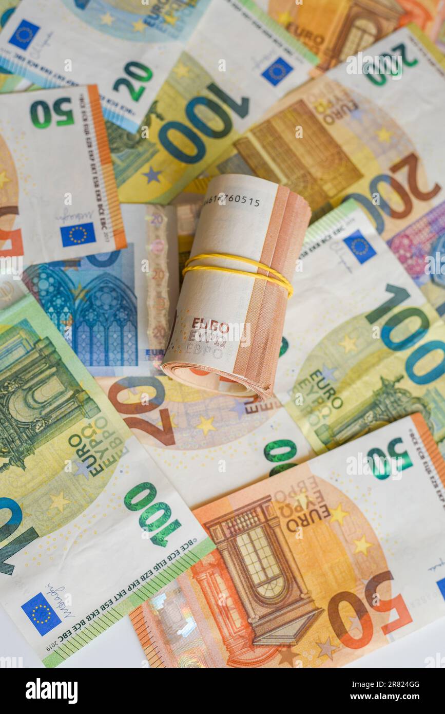 Euros currency spread out across a world map background, illustrating ...