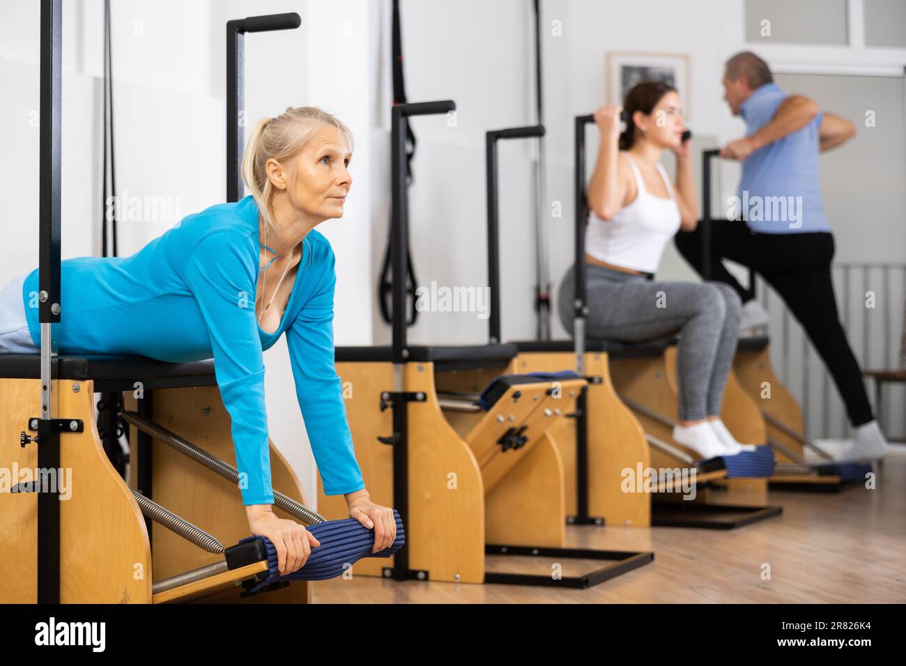 Focused woman performing stretching exercises hi-res stock photography ...