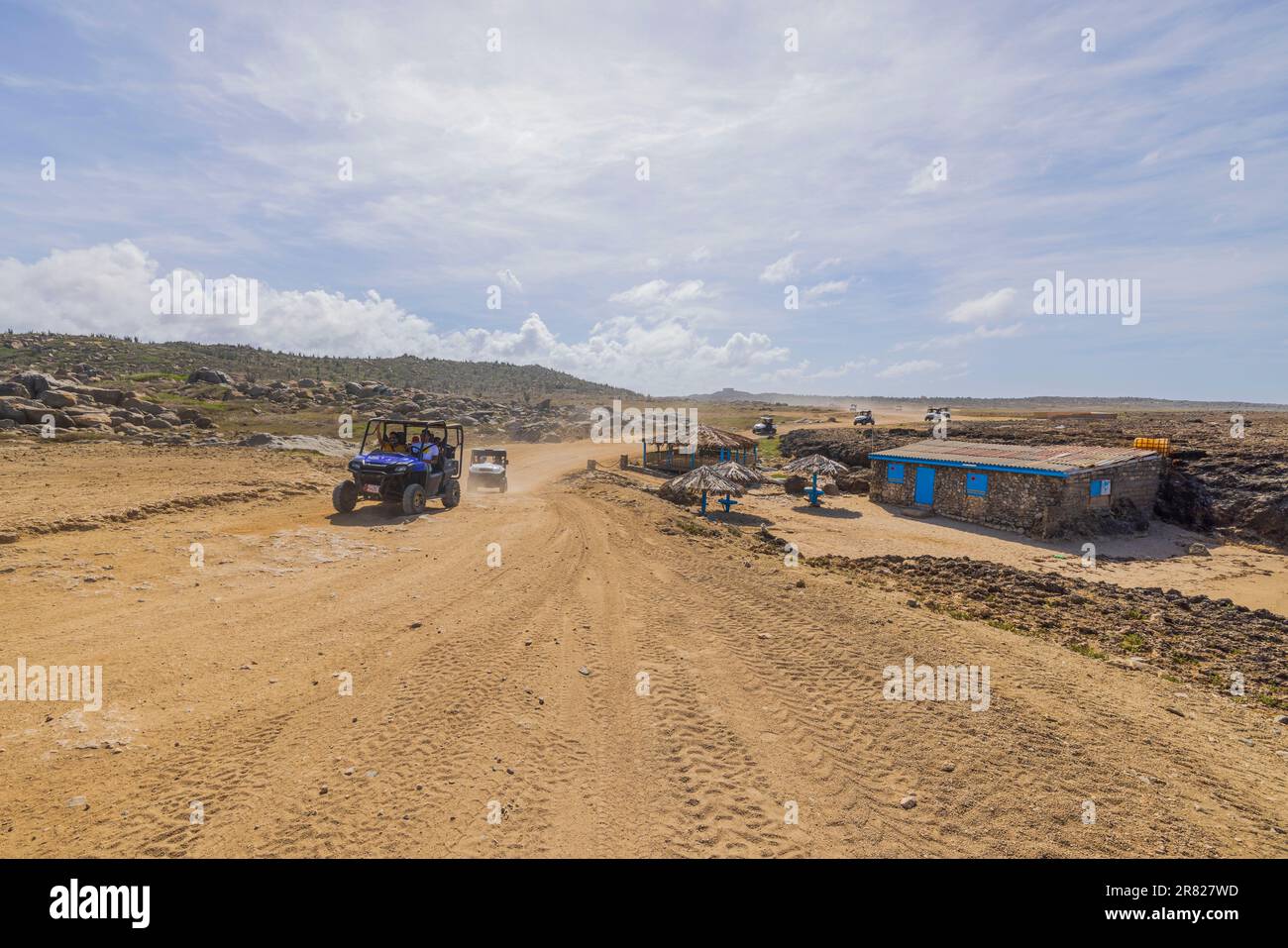 Beautiful view of tourists off-road cars on sandy desert road . Aruba ...