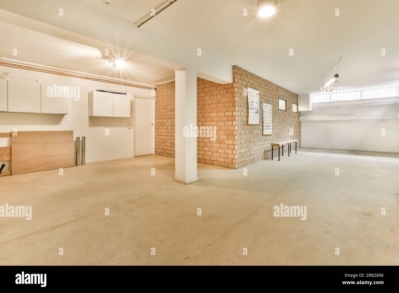 an empty room with brick walls and white cupboards on the wall, there ...