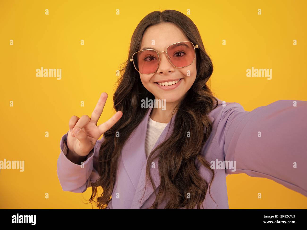 Fashion teen girl in trendy wear making selfie posing on yellow ...