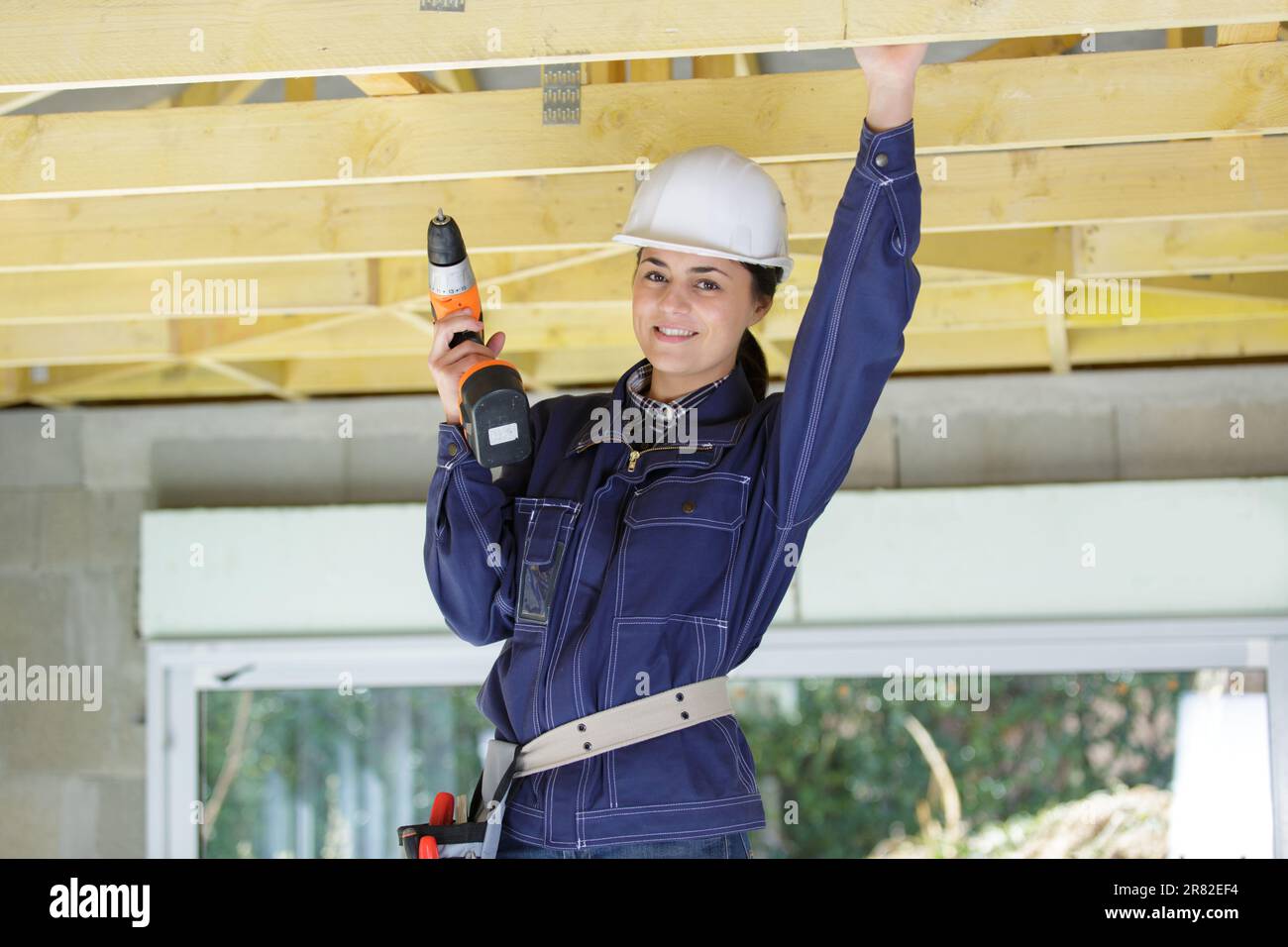 a female builder before drilling a wooden frame Stock Photo - Alamy