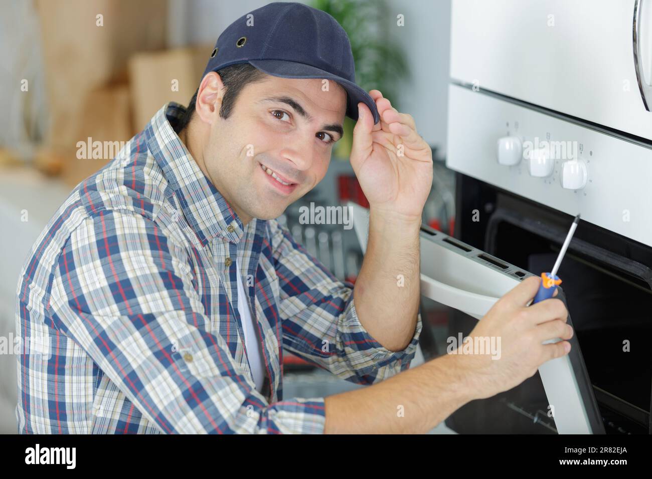expert fixing the kitchen oven Stock Photo - Alamy