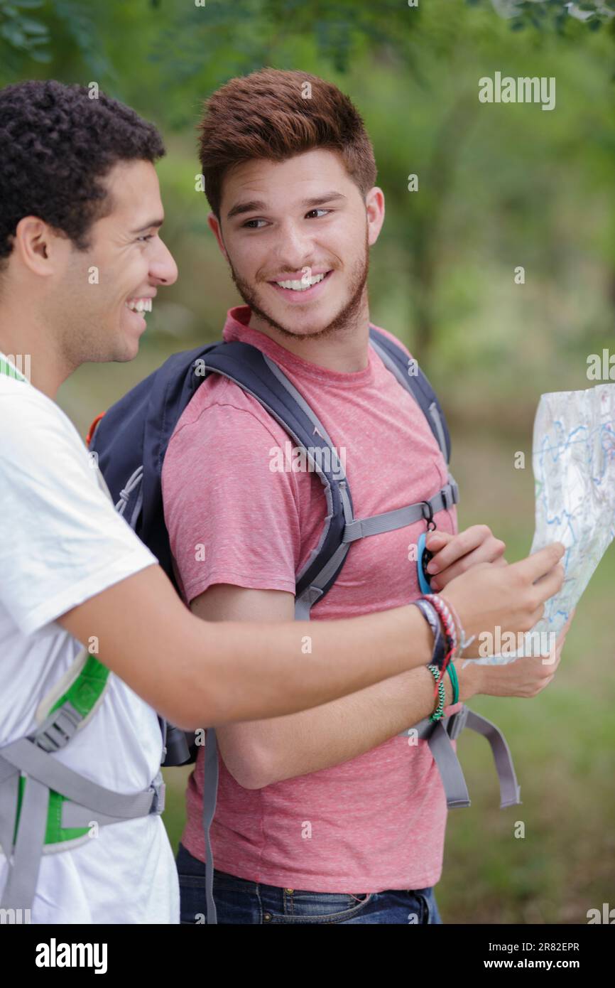 young male hikers looking at map Stock Photo - Alamy