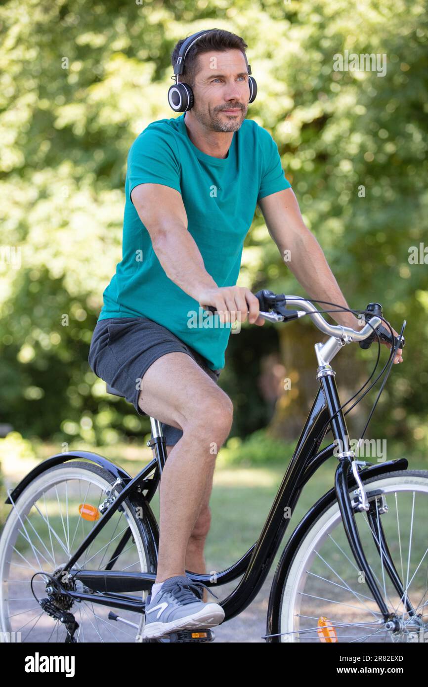 man riding a bike across the city with headphones Stock Photo - Alamy