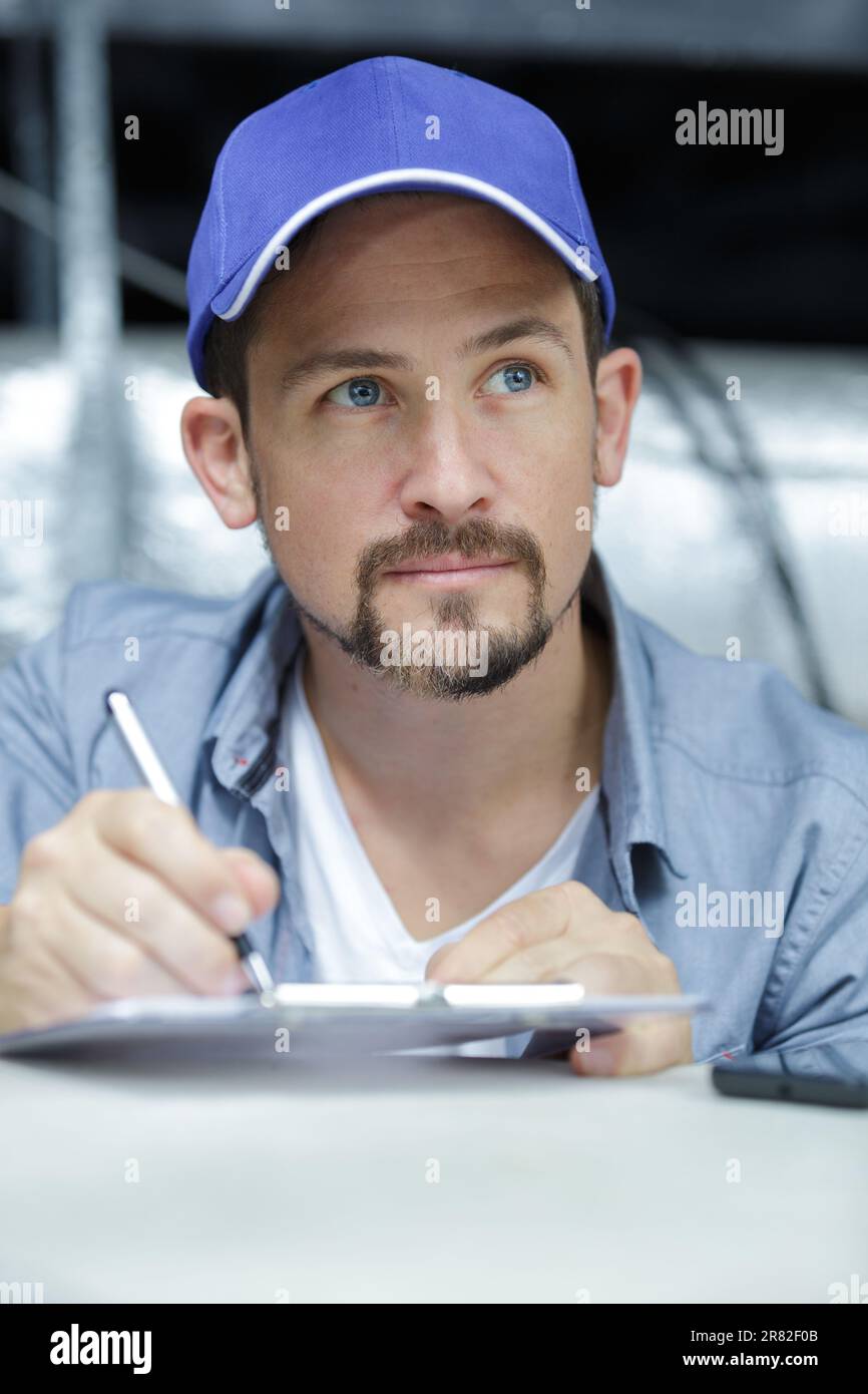 mechanic taking notes on clipboard Stock Photo - Alamy