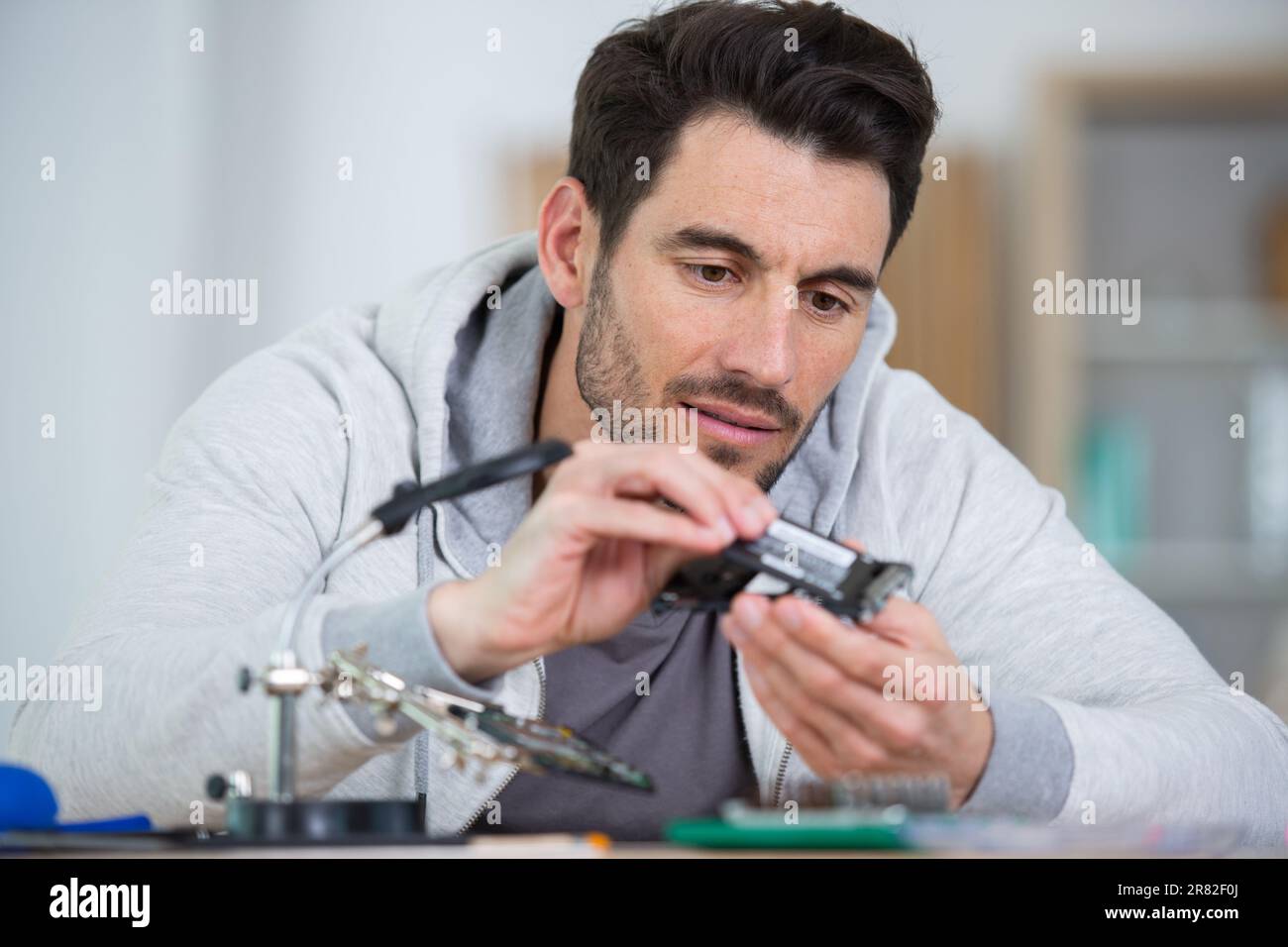 young male technician repairing computer using magnifying glass Stock ...