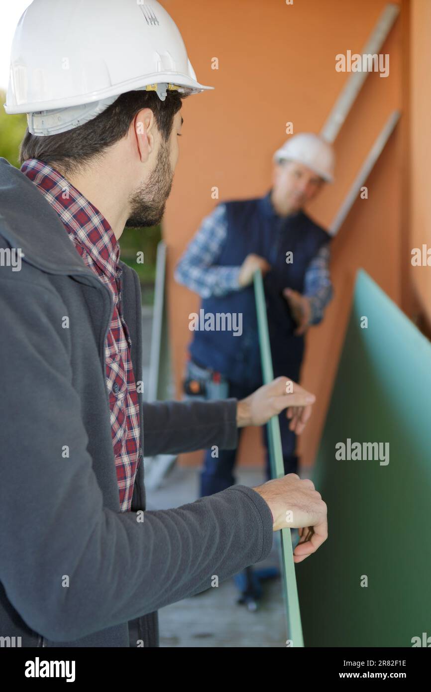 workmen preparing to move large board Stock Photo - Alamy