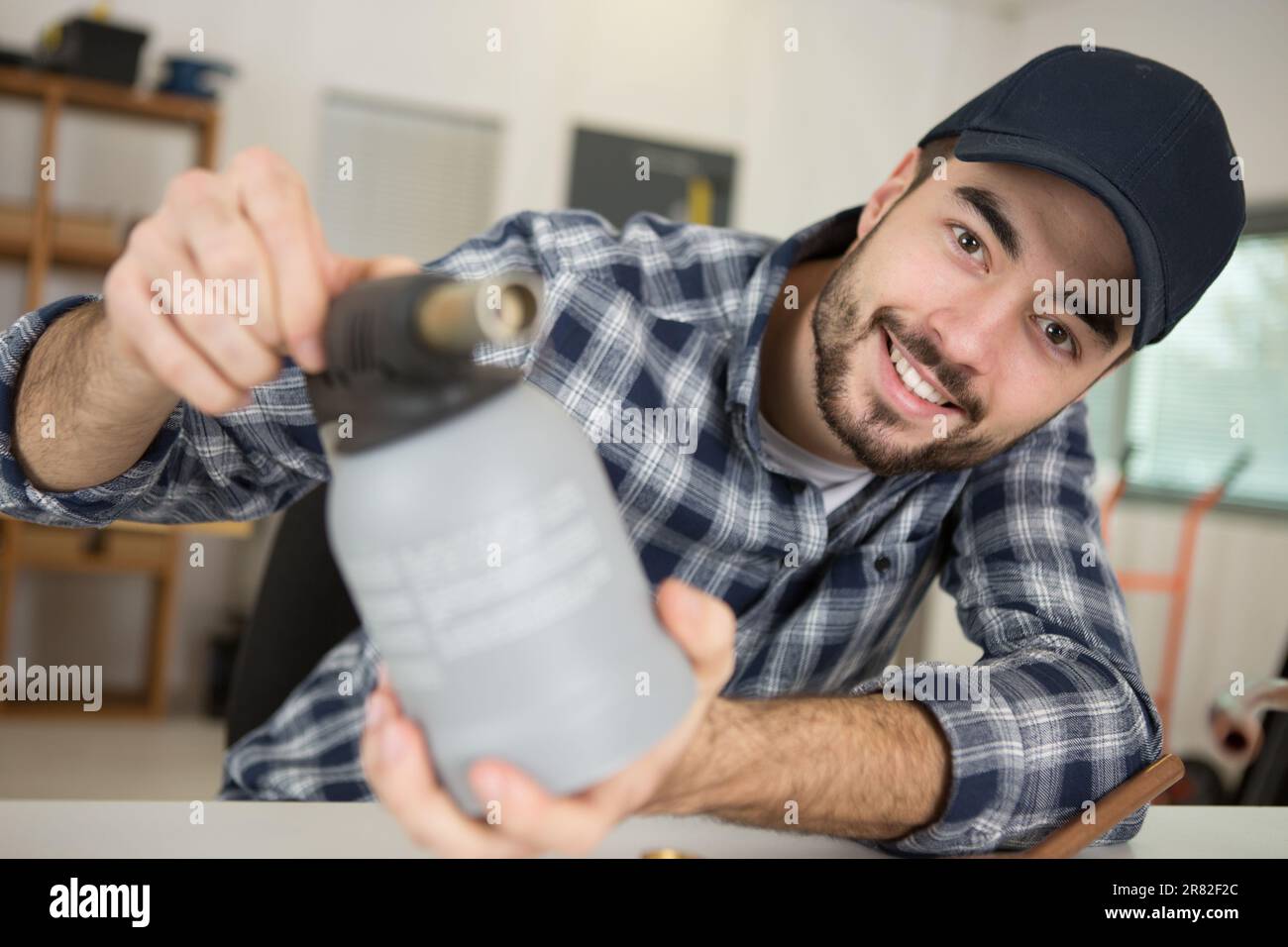 smilling worker holding a blowpipe torch Stock Photo - Alamy