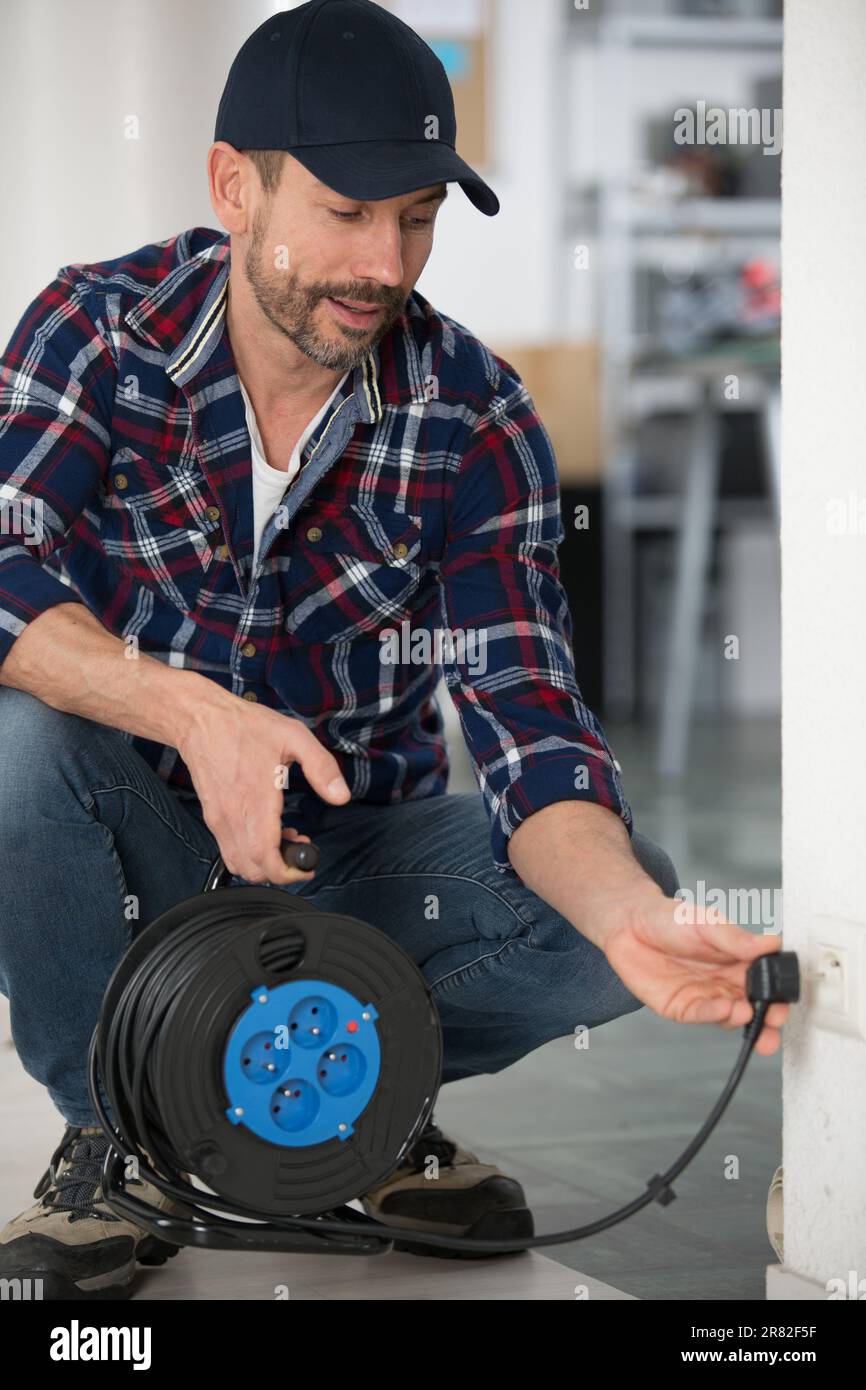 electrician checking plugging an electrical extension cord Stock Photo ...