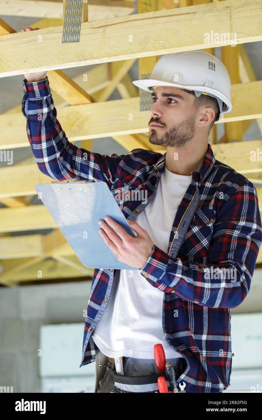 man in a hard hat holding clipboard indoors Stock Photo - Alamy