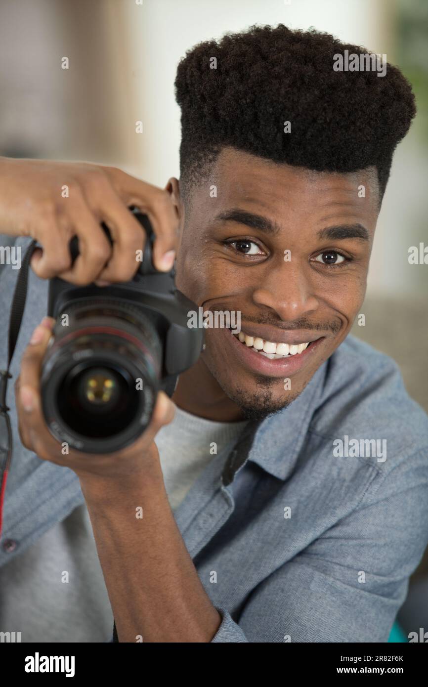 male photographer holding his camera Stock Photo - Alamy