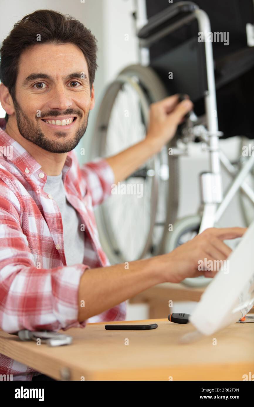 handsome repairman servicing a wheelchair Stock Photo - Alamy