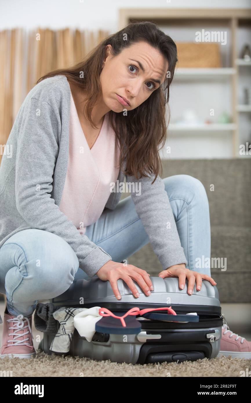 Woman packing suitcase sad hi-res stock photography and images - Alamy