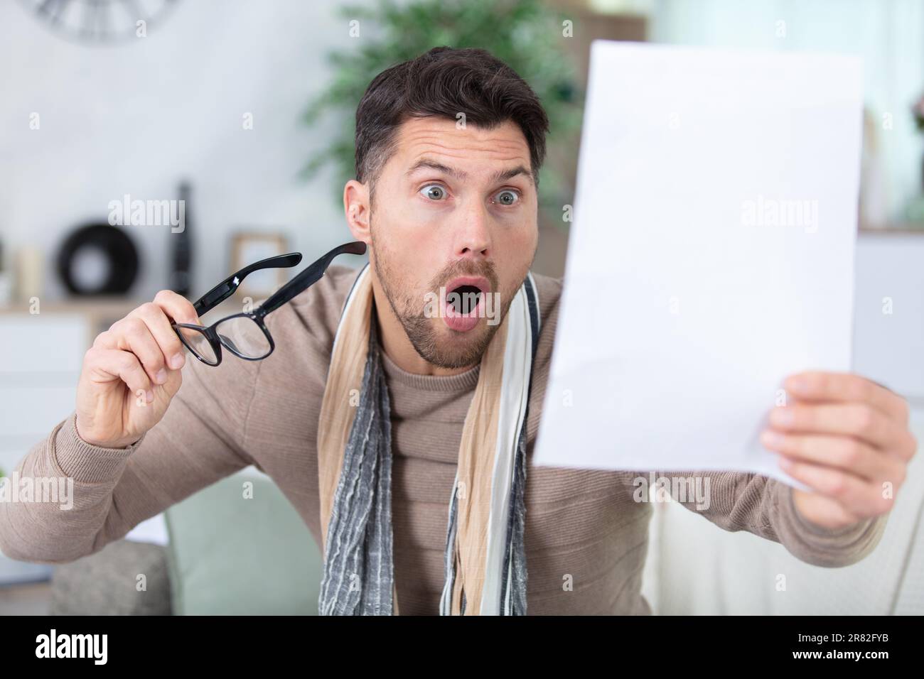 confused frustrated young man holding mail letter Stock Photo - Alamy