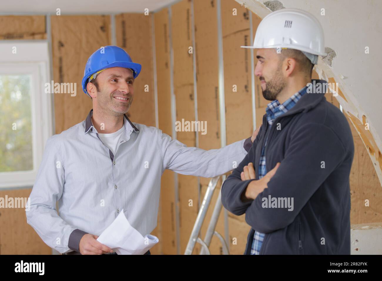 portrait of two builders talking Stock Photo - Alamy