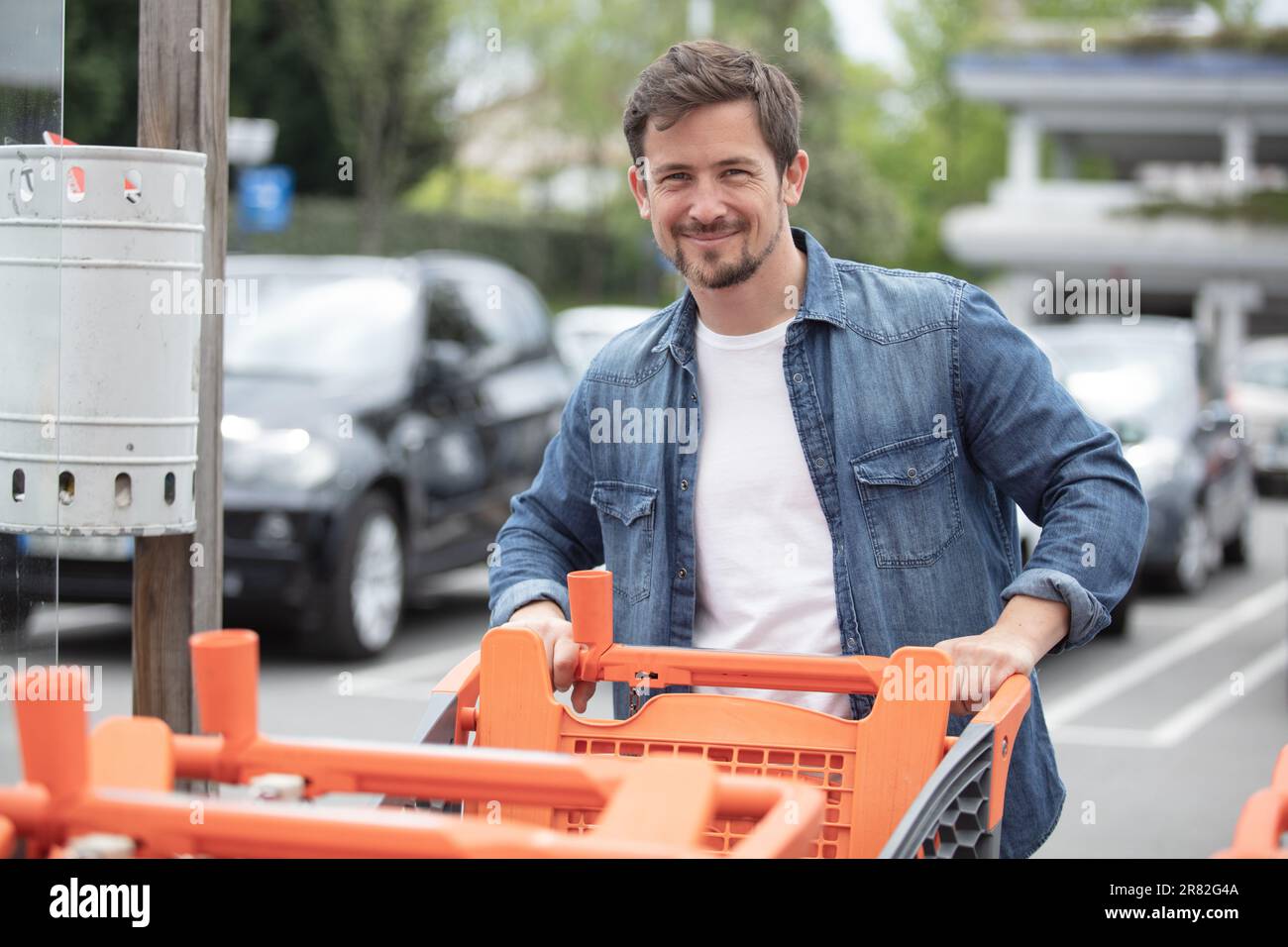man driving shopping cart outside supermarket Stock Photo - Alamy