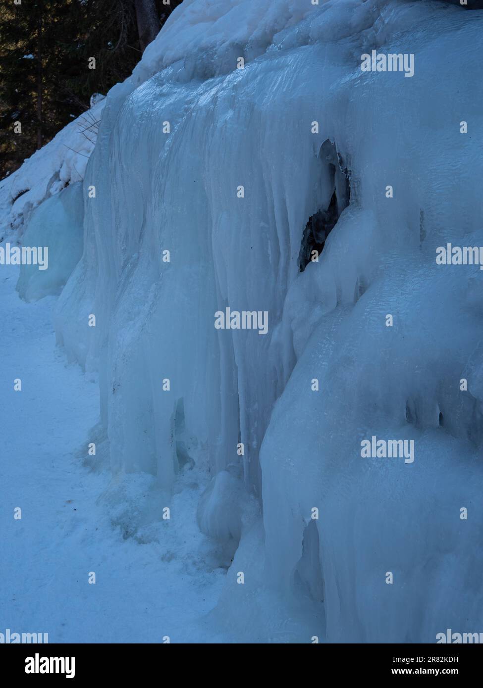 Majestic snow-covered rocks situated beneath large frozen formations ...