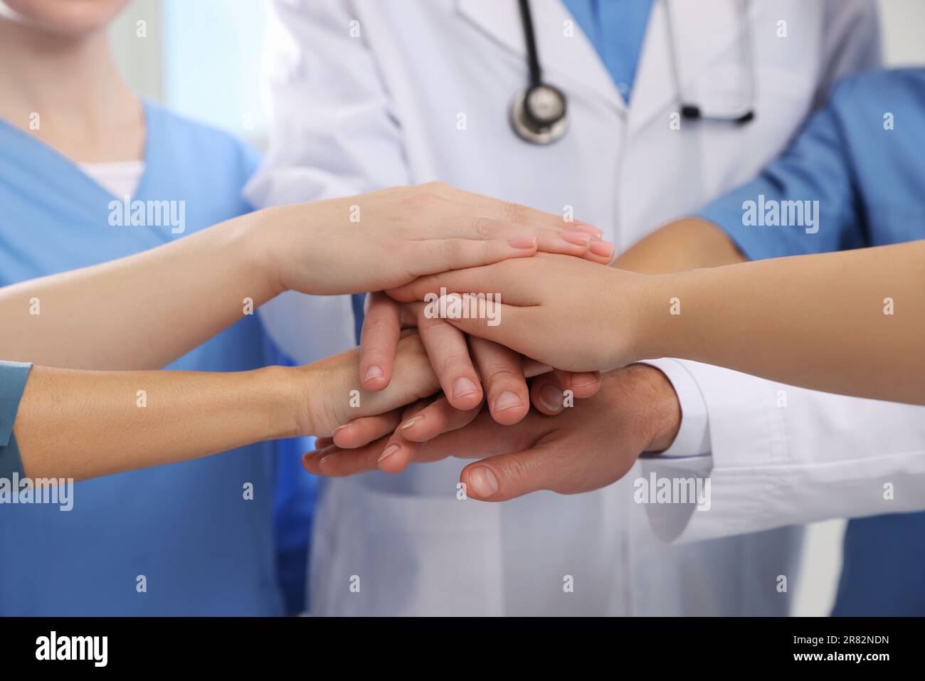 Team of medical doctors putting hands together, closeup Stock Photo - Alamy