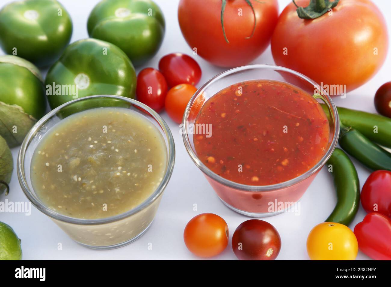 Bowls with delicious salsa sauces and ingredients on white background ...