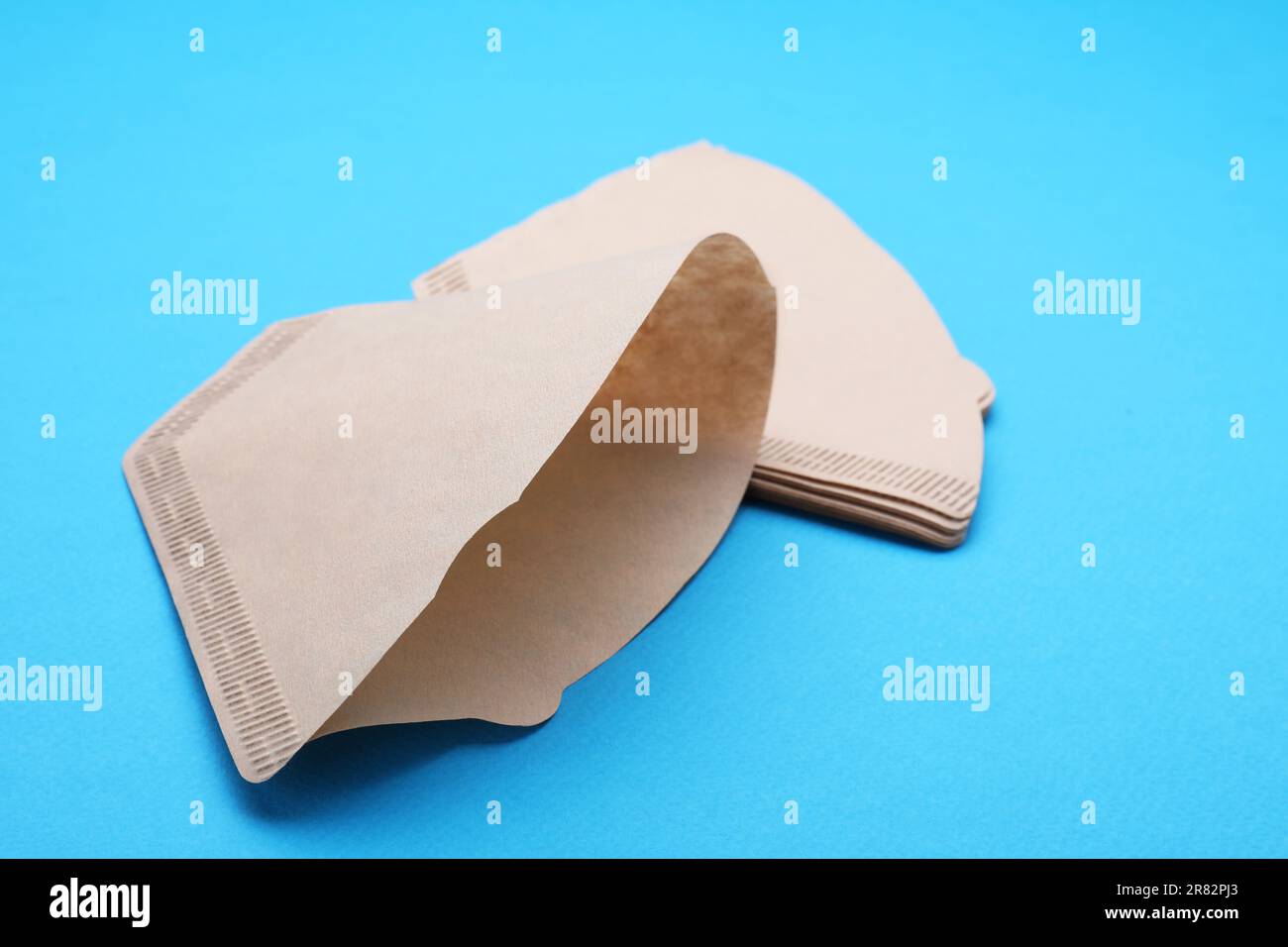 Paper coffee filters on light blue background Stock Photo - Alamy