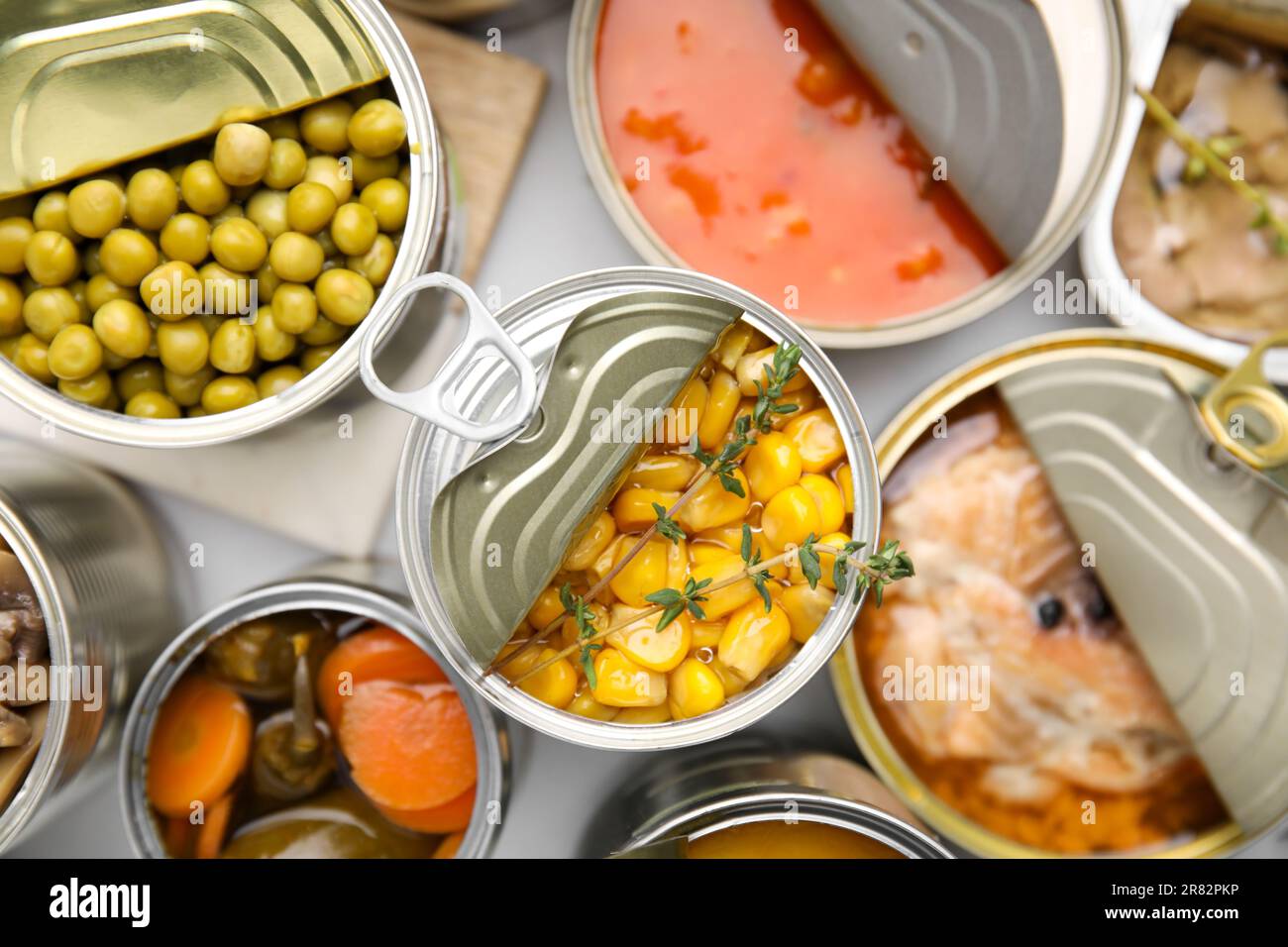 Open tin cans with different products on table, flat lay Stock Photo ...