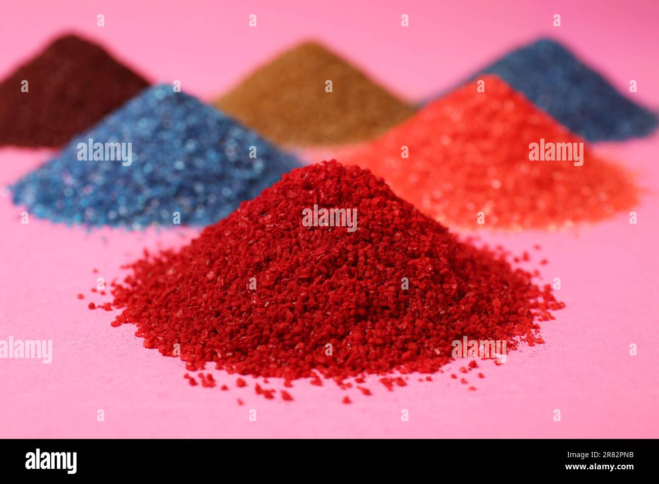 Heaps of different bright food coloring on pink background, closeup ...