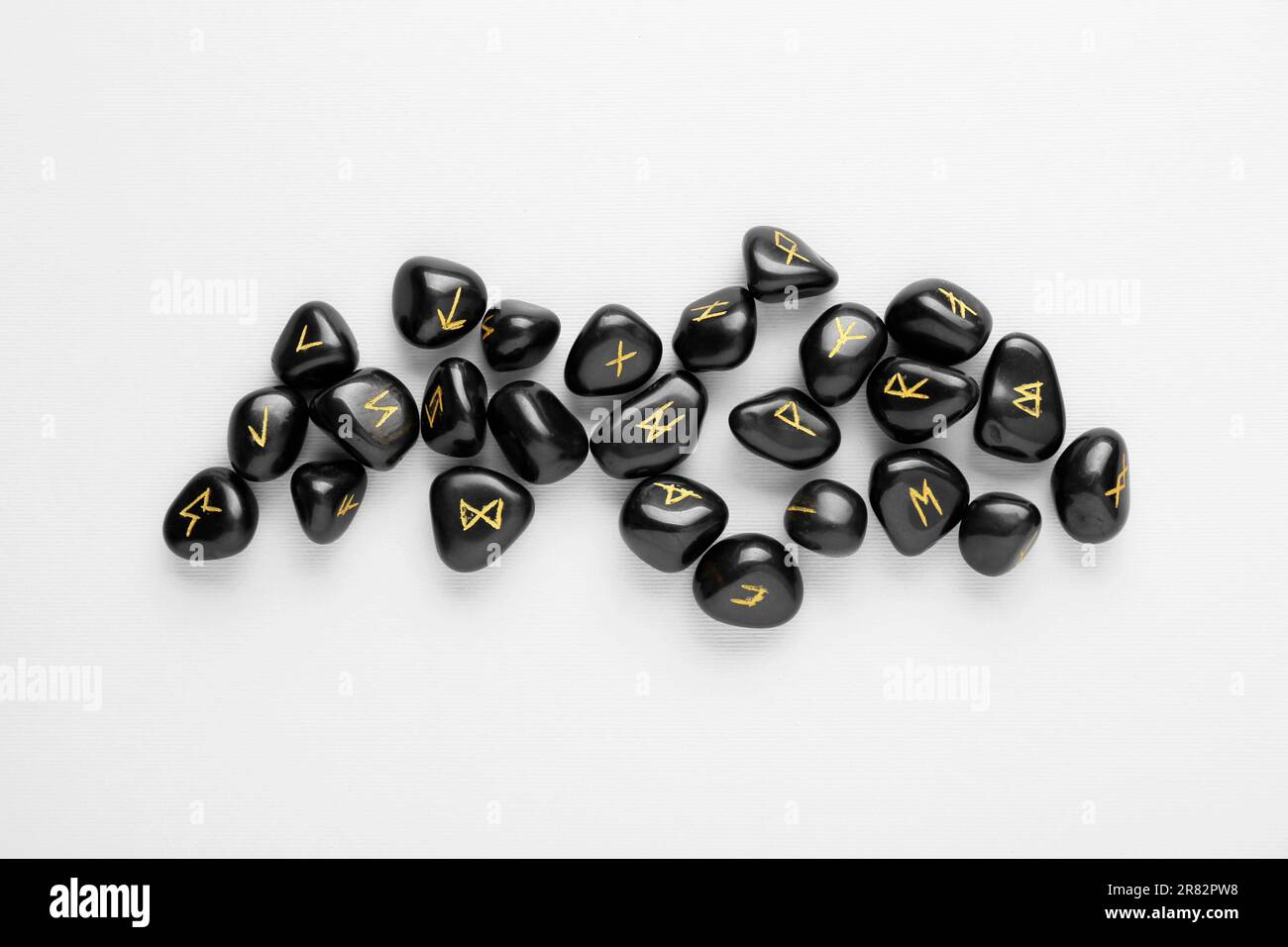 Black rune stones on white background, top view Stock Photo - Alamy
