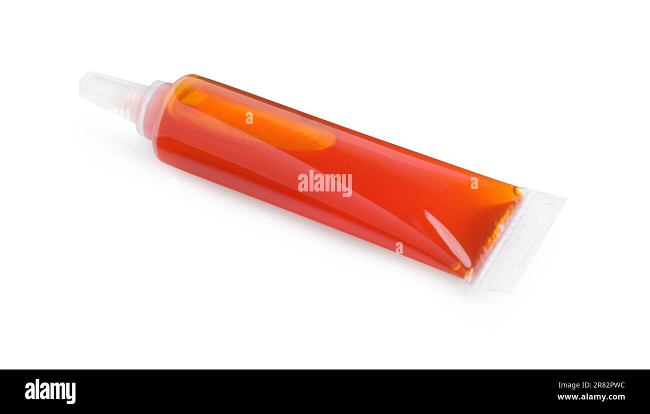 Tube with orange food coloring on white background Stock Photo - Alamy