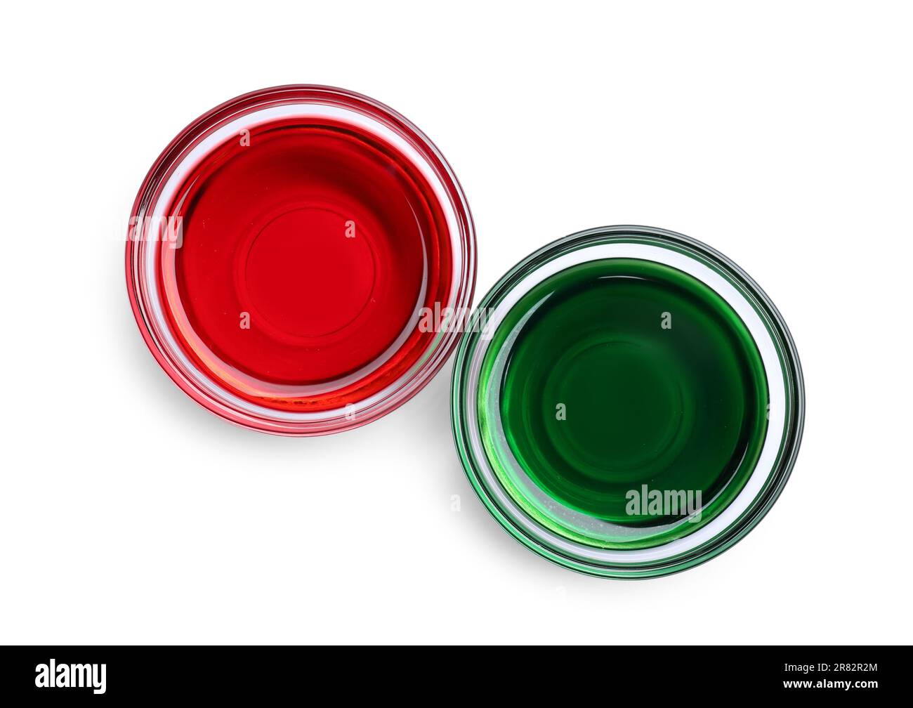 Glass bowls with red and green food coloring on white background, top ...