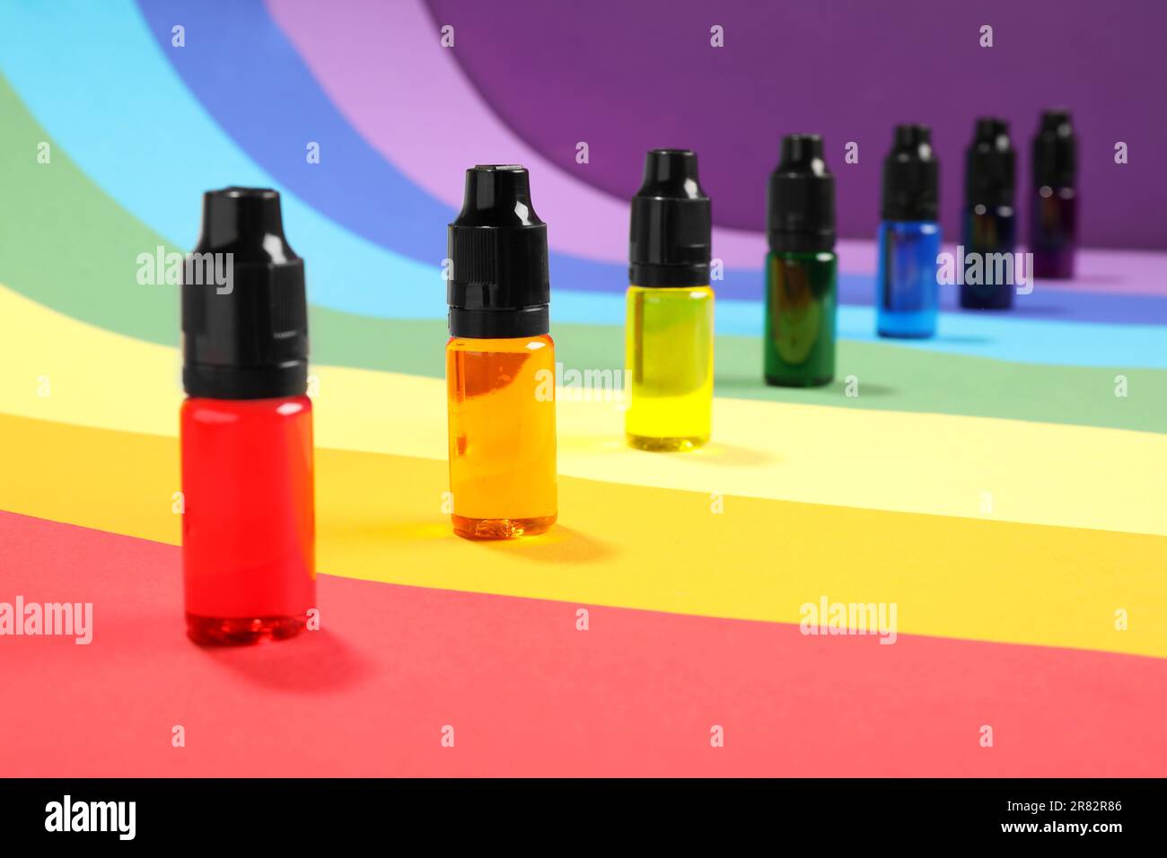 Bottles with different food coloring on rainbow background Stock Photo ...