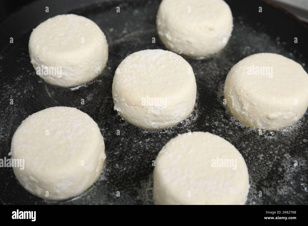 Uncooked cottage cheese pancakes in frying pan, closeup Stock Photo - Alamy