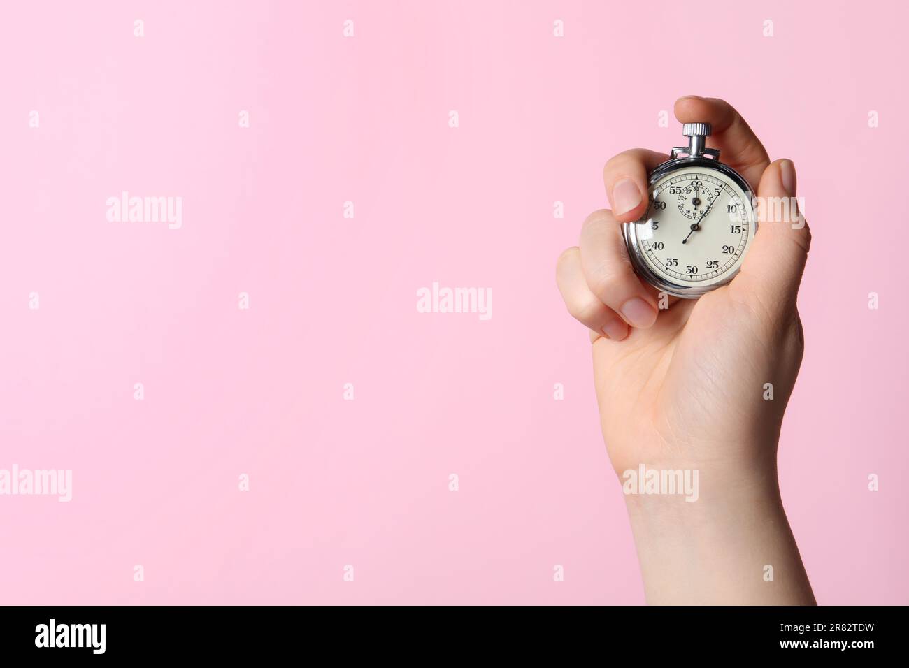 Woman holding vintage timer on pink background, closeup. Space for text ...