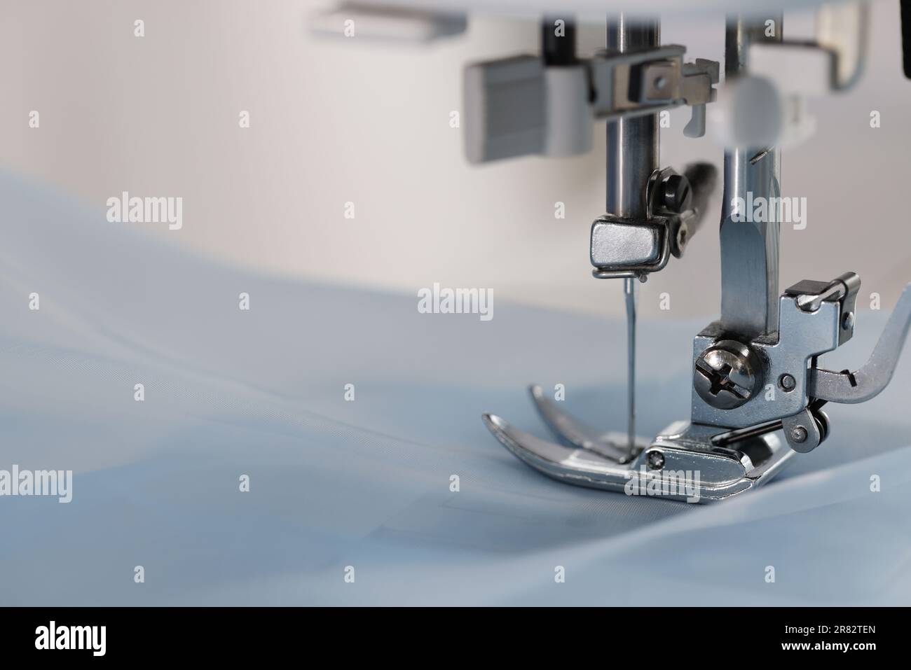 Sewing machine with light blue fabric, closeup. Space for text Stock ...
