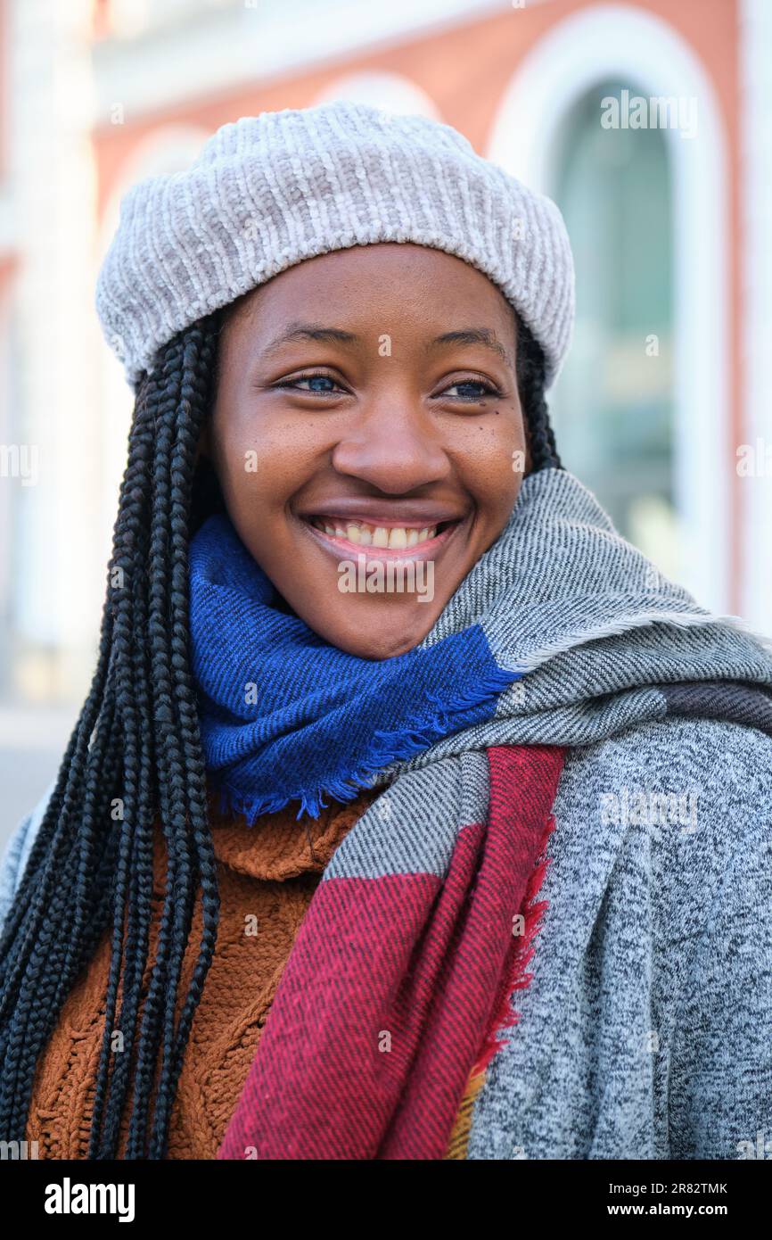 Portrait of young african woman with heterochromia smiling in winter ...
