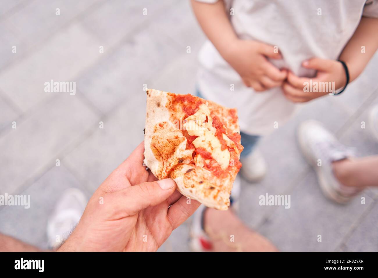 Two people eating pizza in the park. Pizza delivery concept in a ...