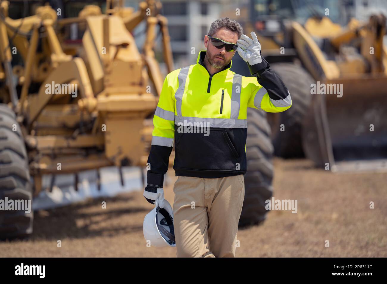 Machinery builder at buildings background. Excavator loader tractor and ...