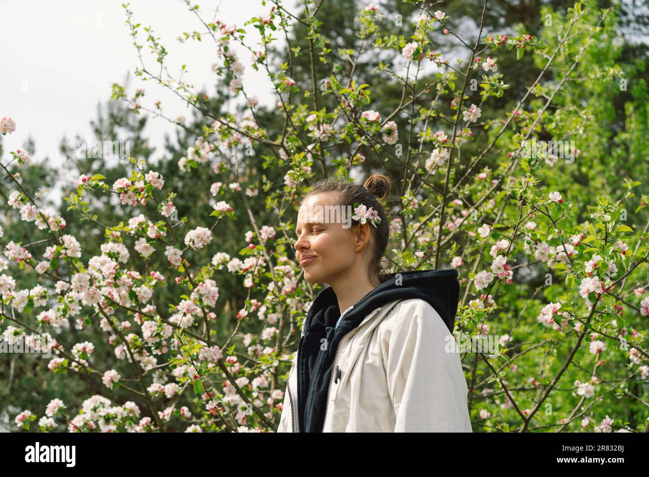 Beautiful young woman with spring flowers enjoying nature and laughing ...