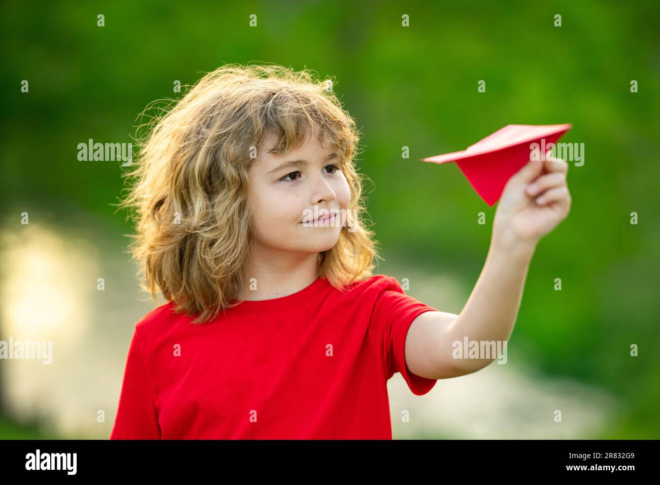 Fun kid boy dreams of becoming an aviator playing paper plane outdoor ...