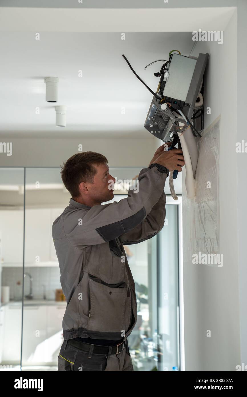 Man technician repairing apartment air conditioner Stock Photo - Alamy Man technician repairing apartment air conditioner Stock Photo - Alamy