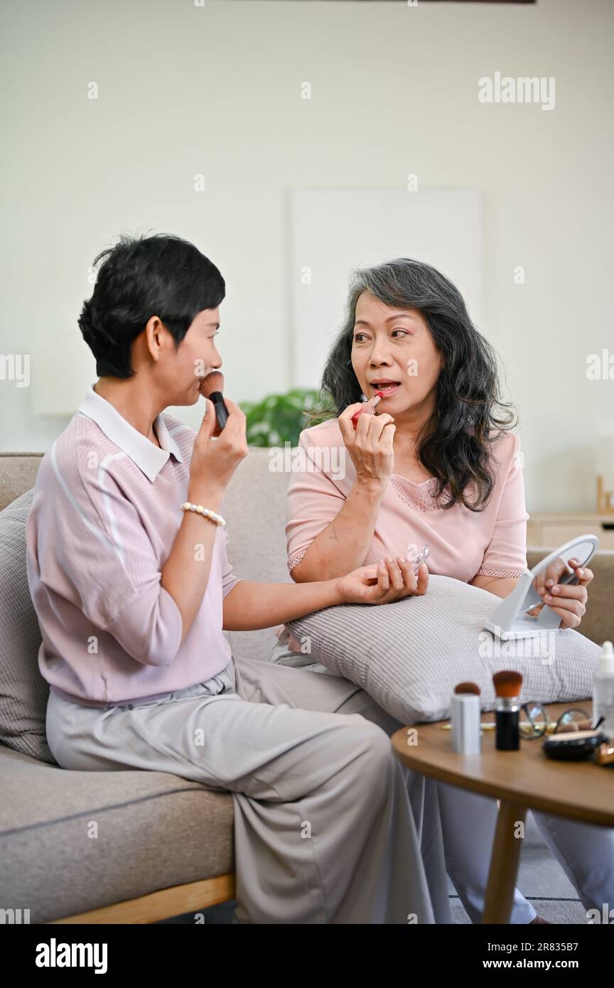 Two cheerful and lovely retired Asian female besties are enjoying ...