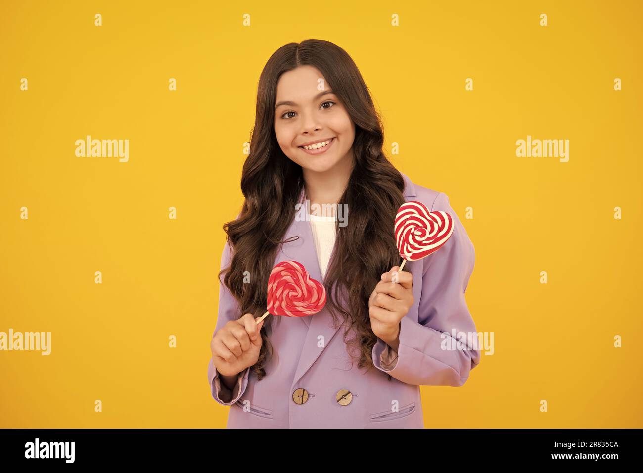 Cool teen child with lollipop over yellow isolated background. Sweet ...