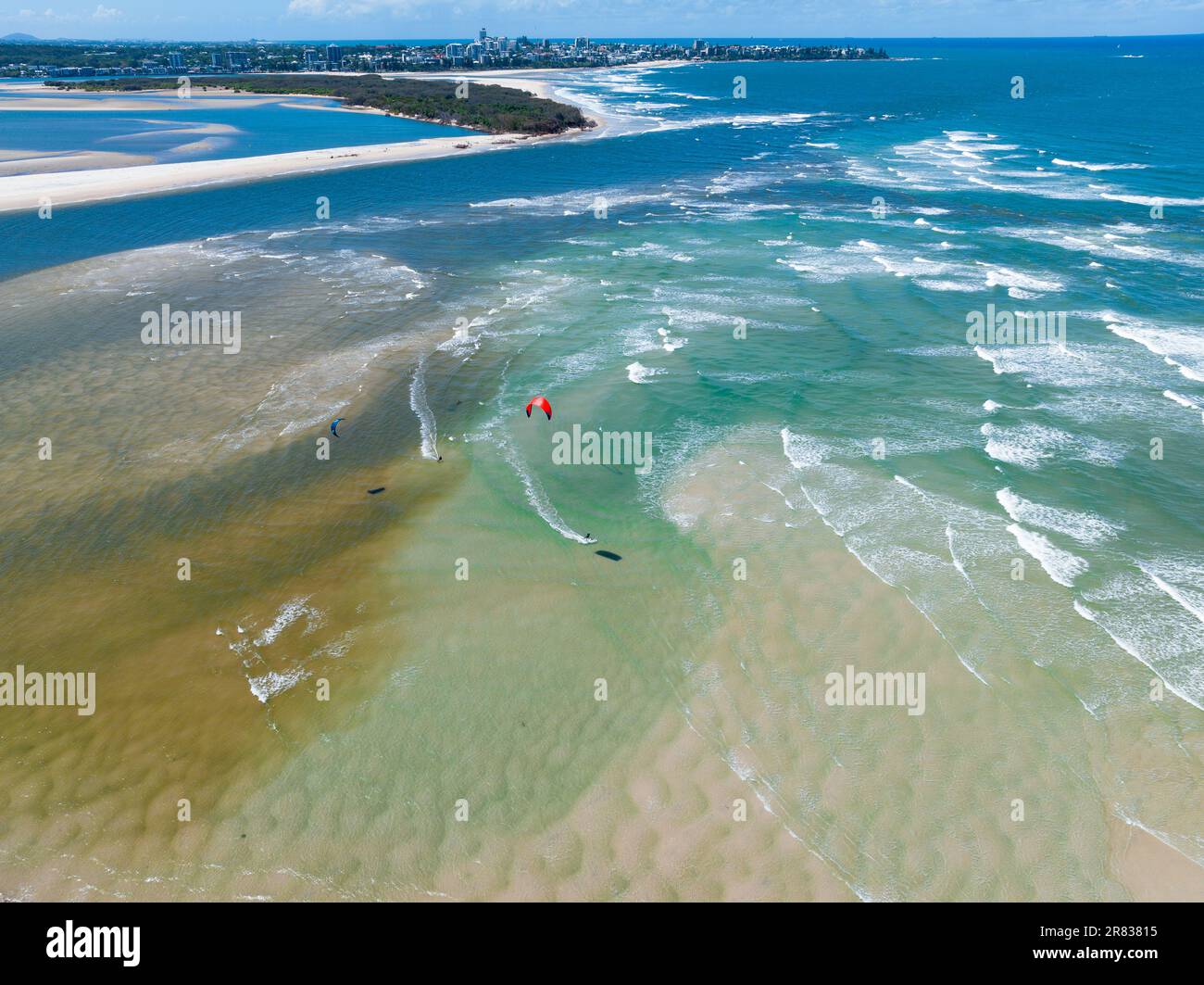 Aerial view of parasailing over waves near a coastal river mouth at ...