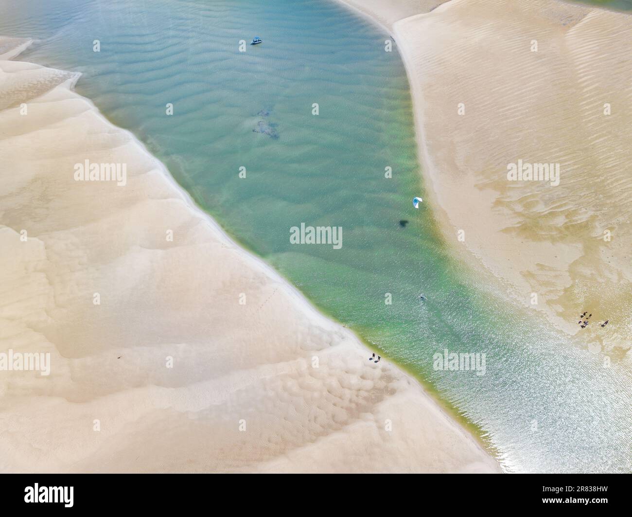 Aerial view of kite surfing on a river flowing between sand bars at ...