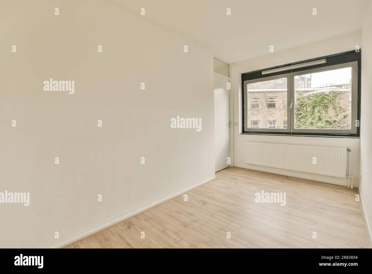 an empty room with white walls and hardwood flooring the room is very ...