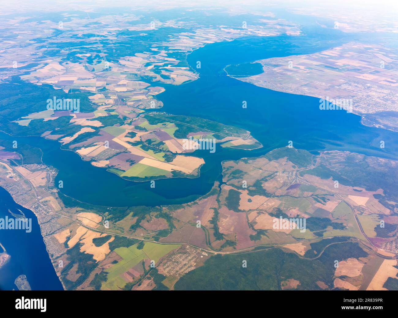 Aerial view from airplane window above green ground. View from the ...