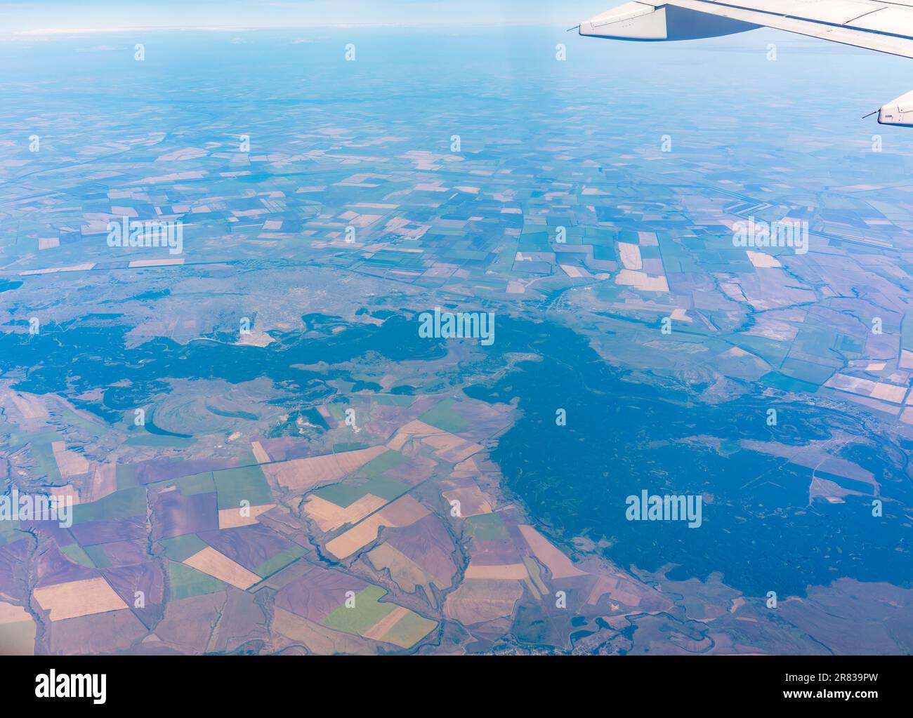 Aerial view from airplane window above green ground. View from the ...