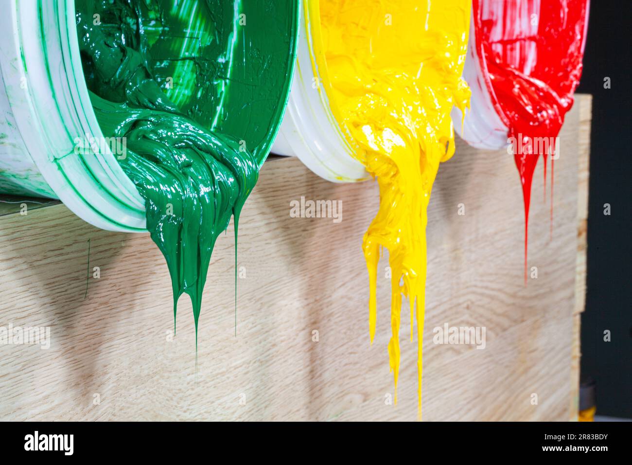 green yellow and orange paints are dripping from white barrel. high ...