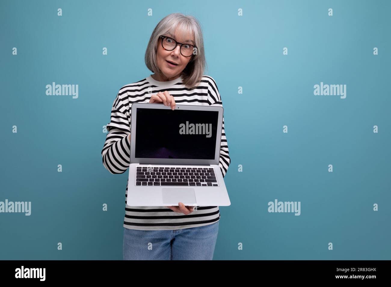 middle aged business woman demonstrates a laptop screen with a mockup ...
